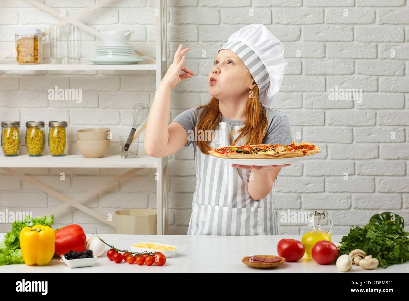 child making tasty delicious gesture by kissing fingers. little girl in ...