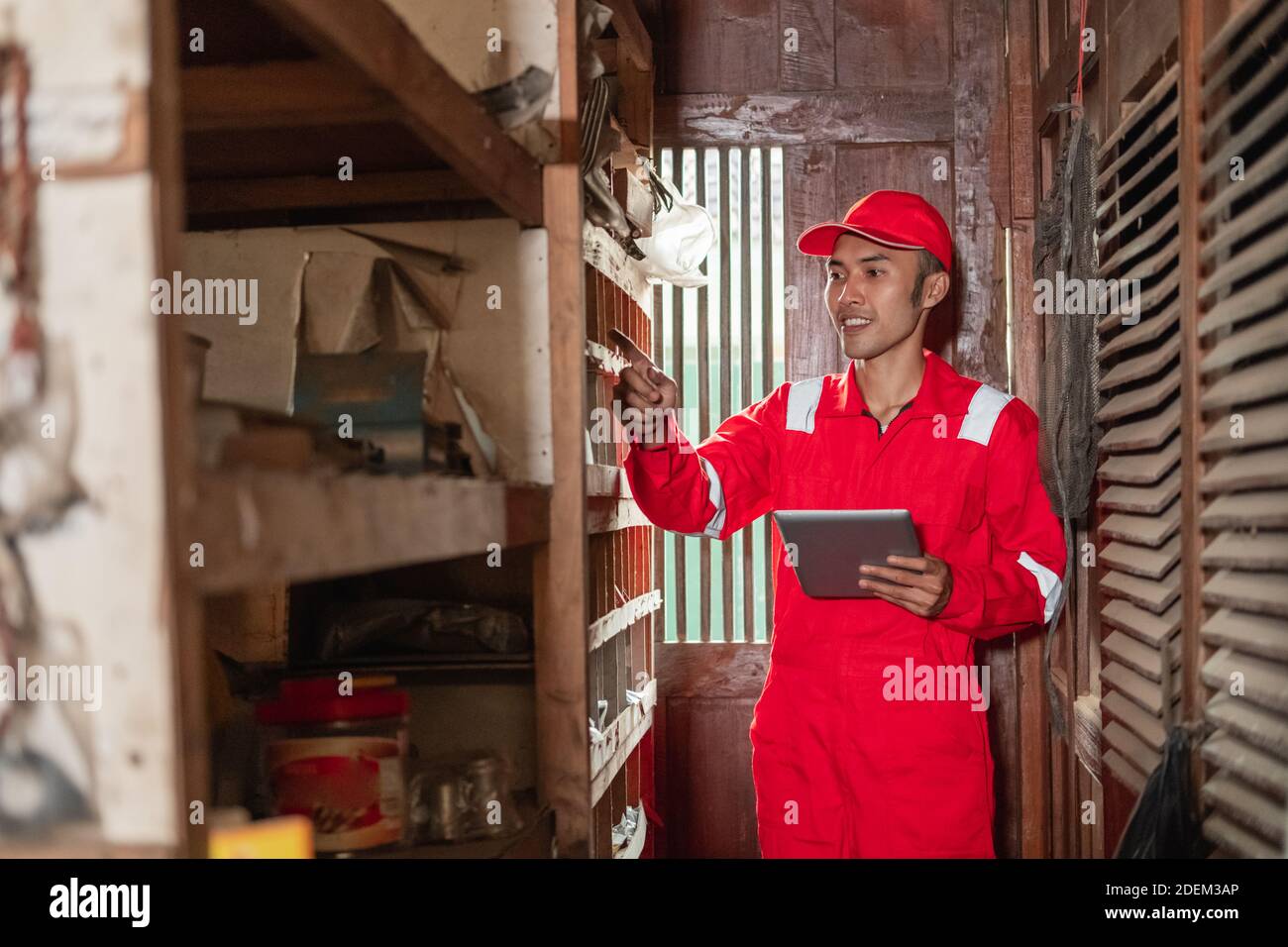 mechanics in wearpack and hat uniforms use digital tablets when ...