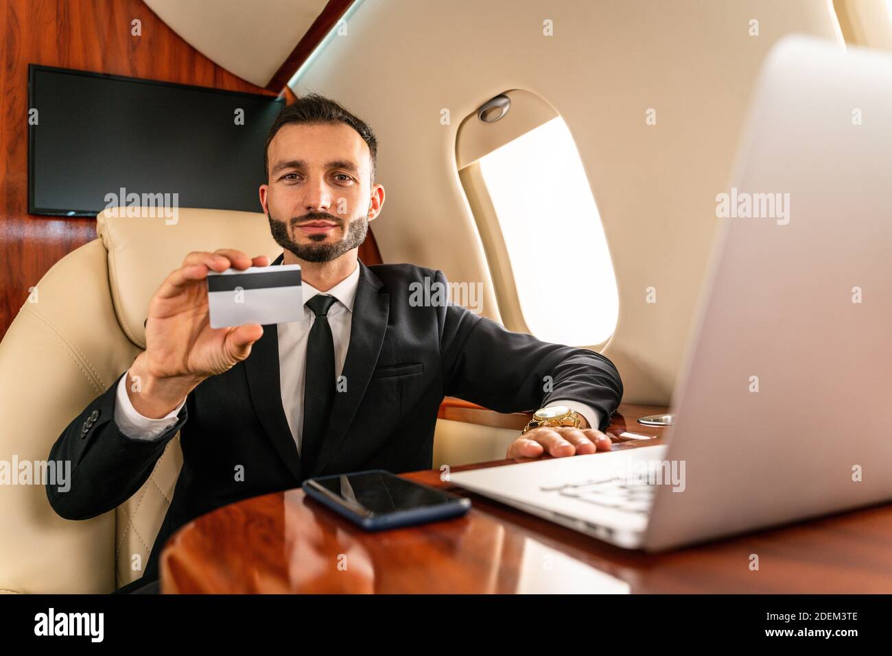 Handsome businessman wearing elegant suit flying on exclusive private ...
