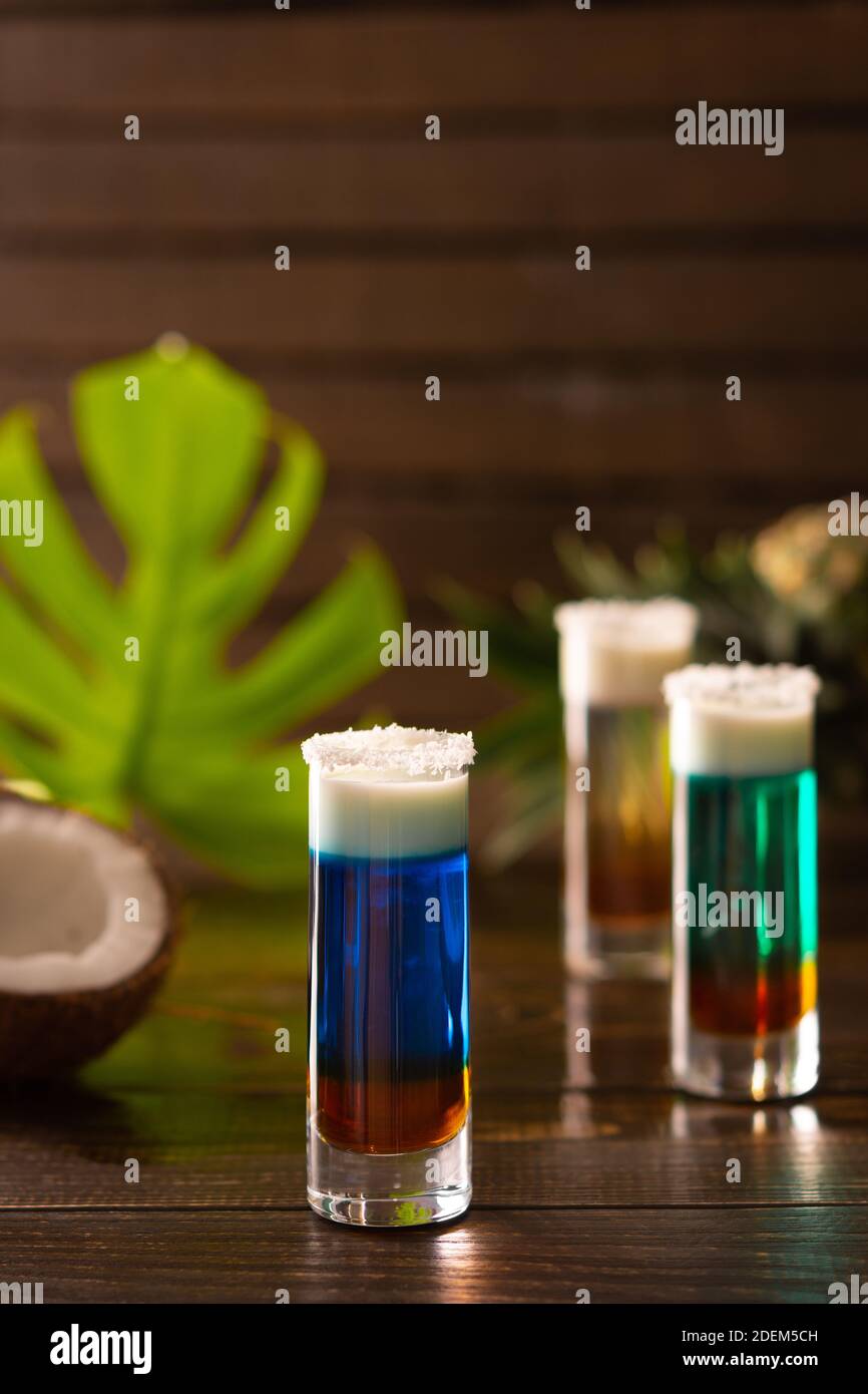 Tropical alcoholic shots decorated with coconut flakes, monstera flower ...
