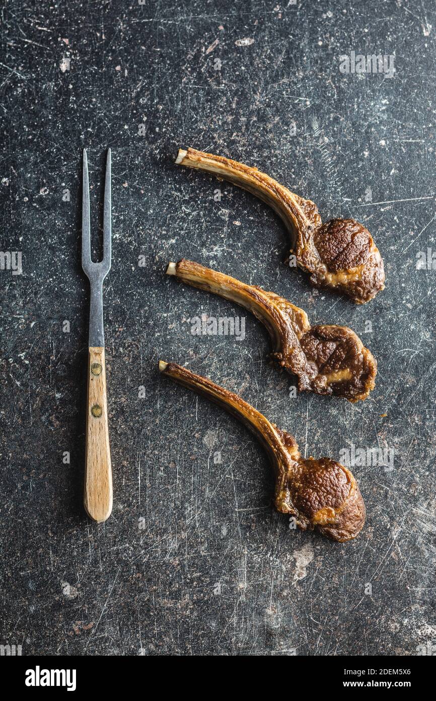 Grilled lamb chops on black table. Top view Stock Photo - Alamy