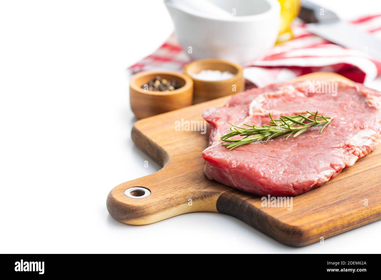 Sliced raw ribeye steak on cutting board isolated on white background ...