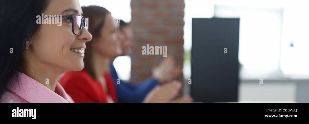 Business people sit at table smiling and clap their hands Stock Photo ...