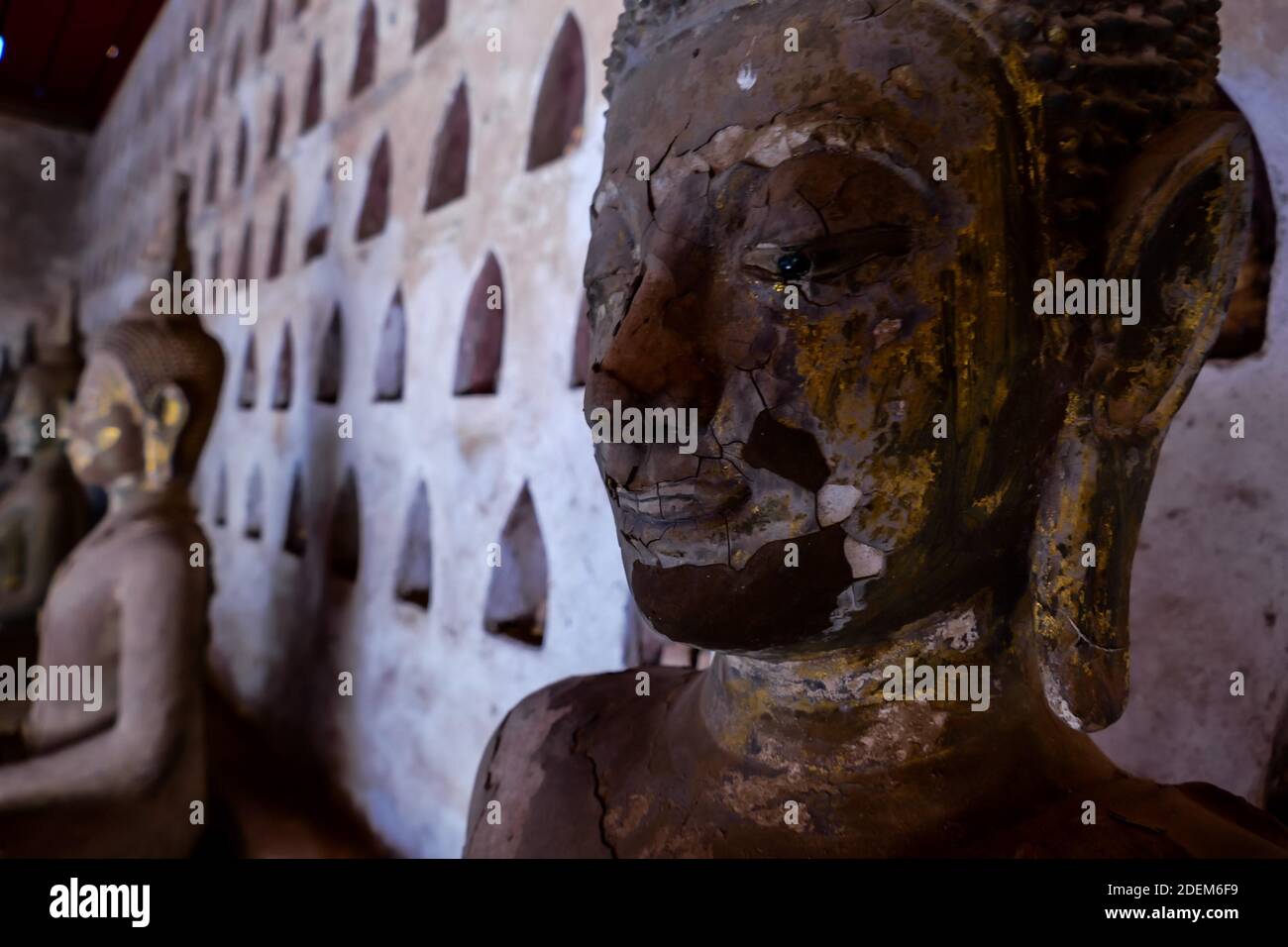 A selective focus shot of a rusty old Buddha statue face in Vientiane ...