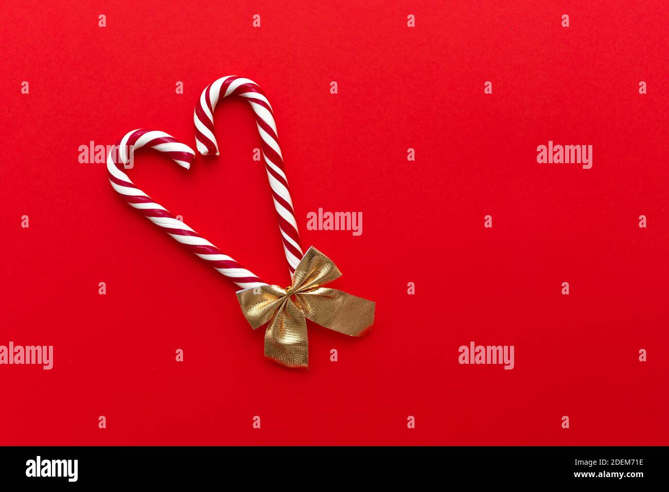 Two candy canes making a heart on a red textured background, Candy cane ...