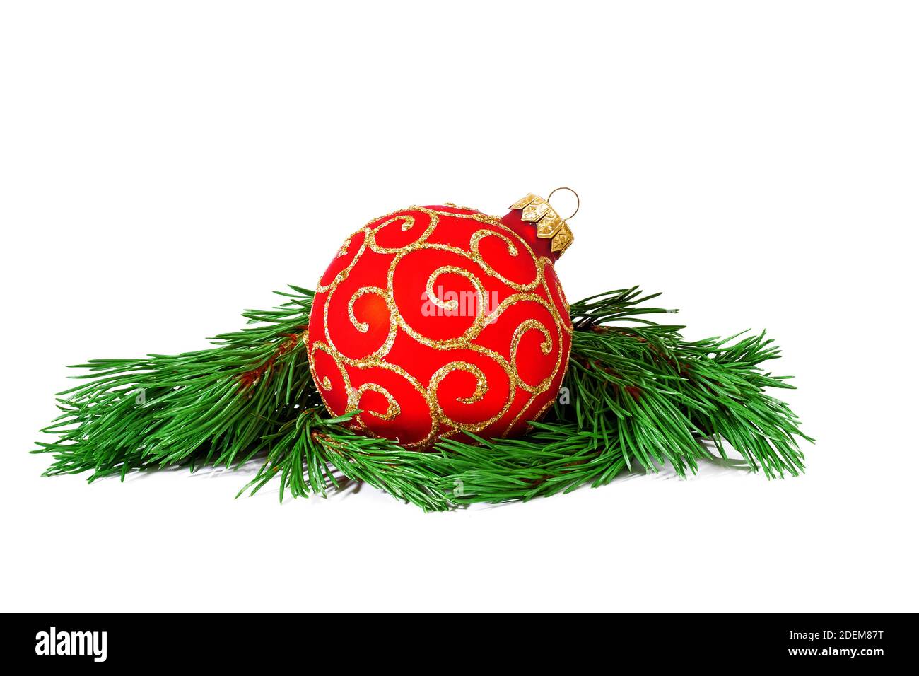 red christmas ball with green pine tree branches isolated on white ...