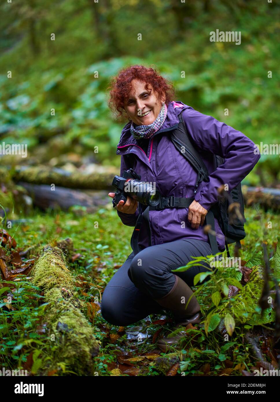 Woman nature photographer with professional camera hiking by the river ...