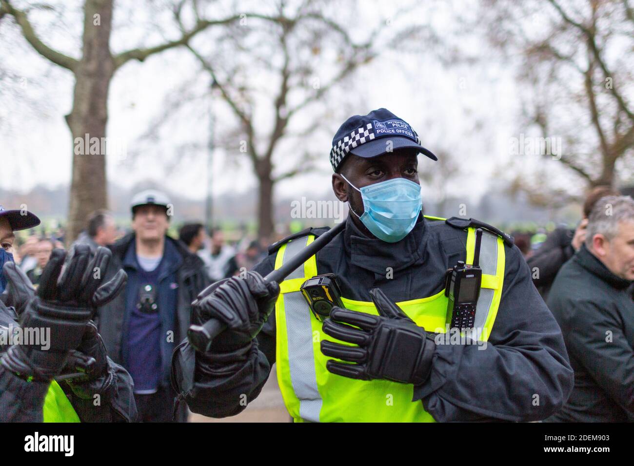Anti-lockdown protest, London, 28 November 2020. A black police officer ...