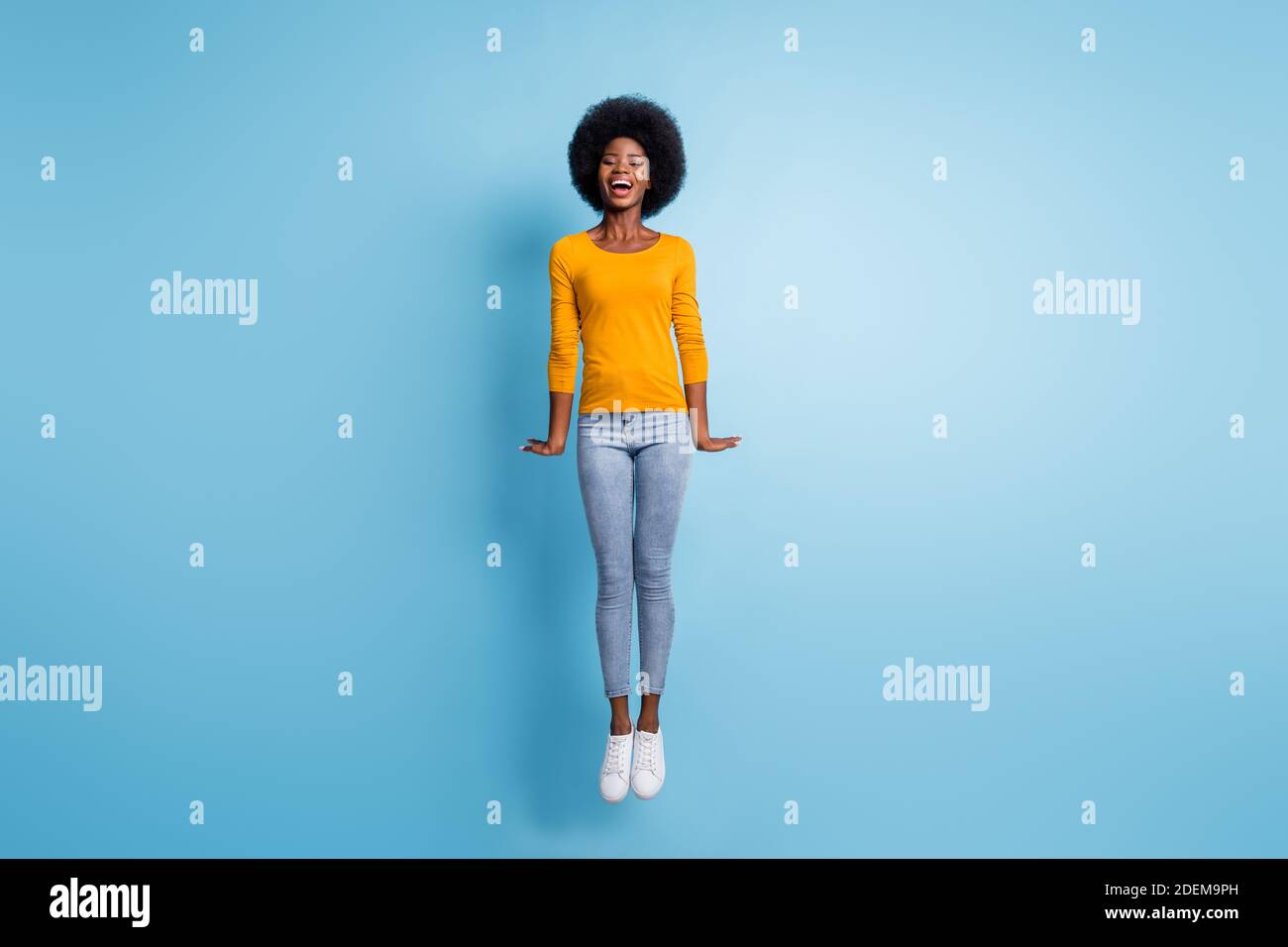 Photo portrait full body of woman jumping straight up isolated on pastel blue colored background ...