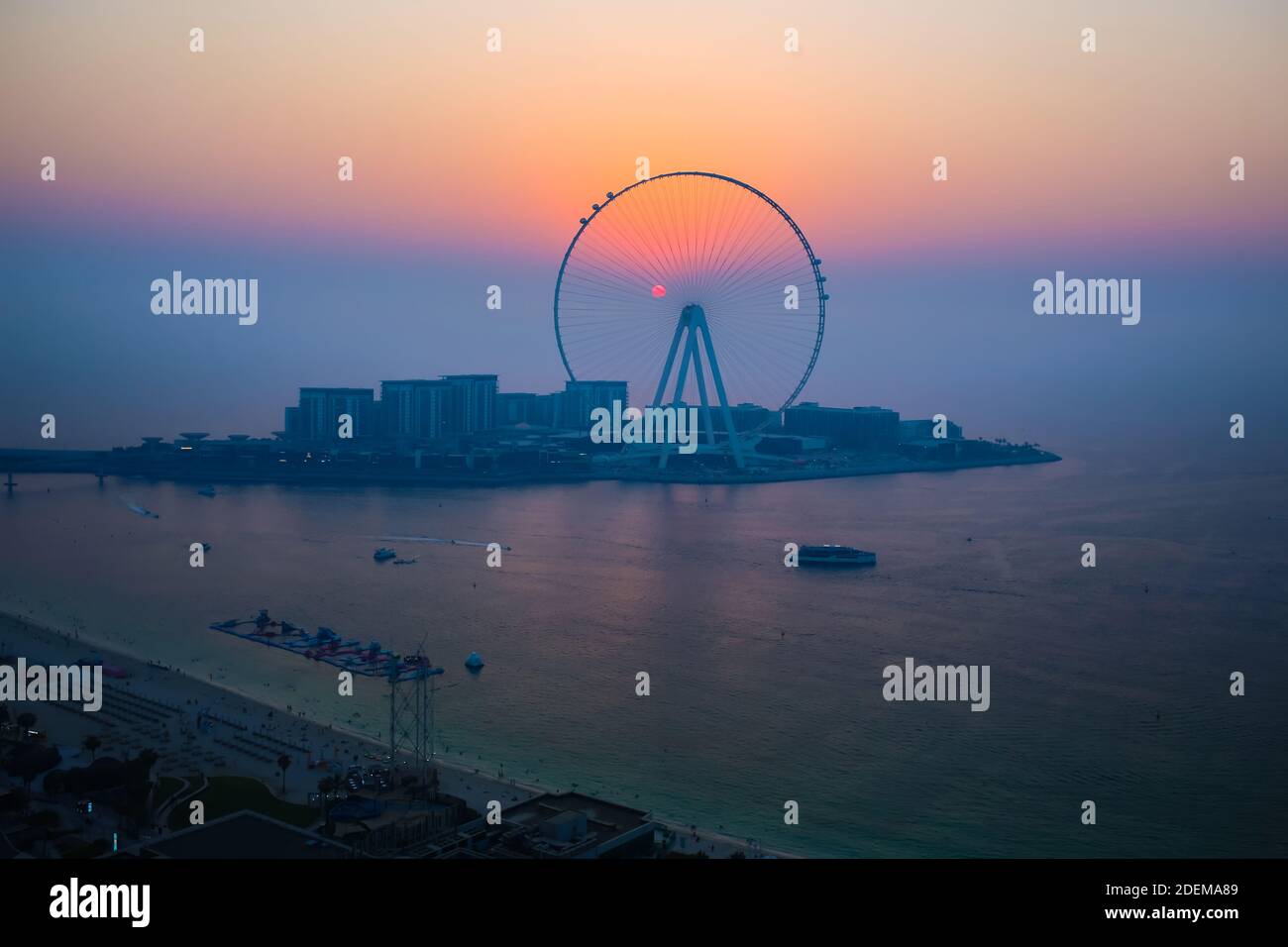 Evening sunset view of Dubai eye ferris wheel with sun inside and six ...