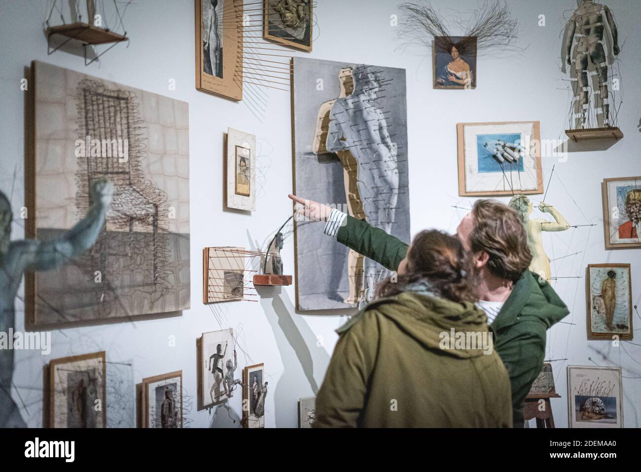 People looking and pointing at art on the wall Stock Photo - Alamy