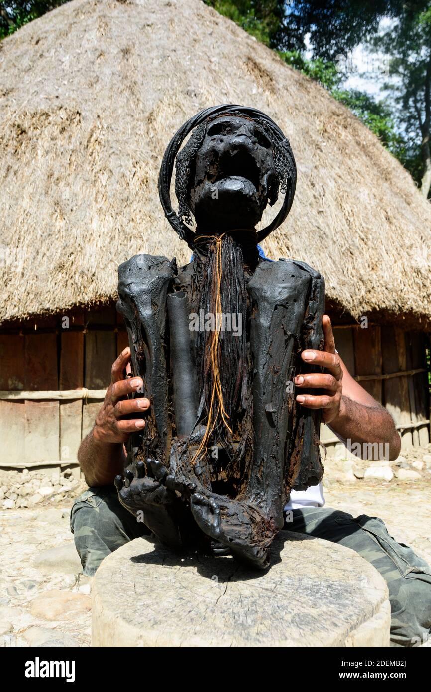 Villager showing the mummy of a former Dani chief in his village ...