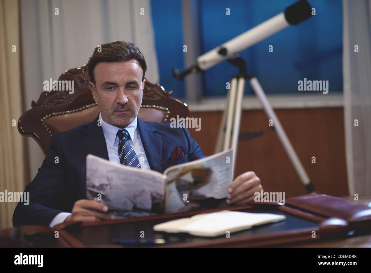 corporate business man at office reading magazine Stock Photo - Alamy