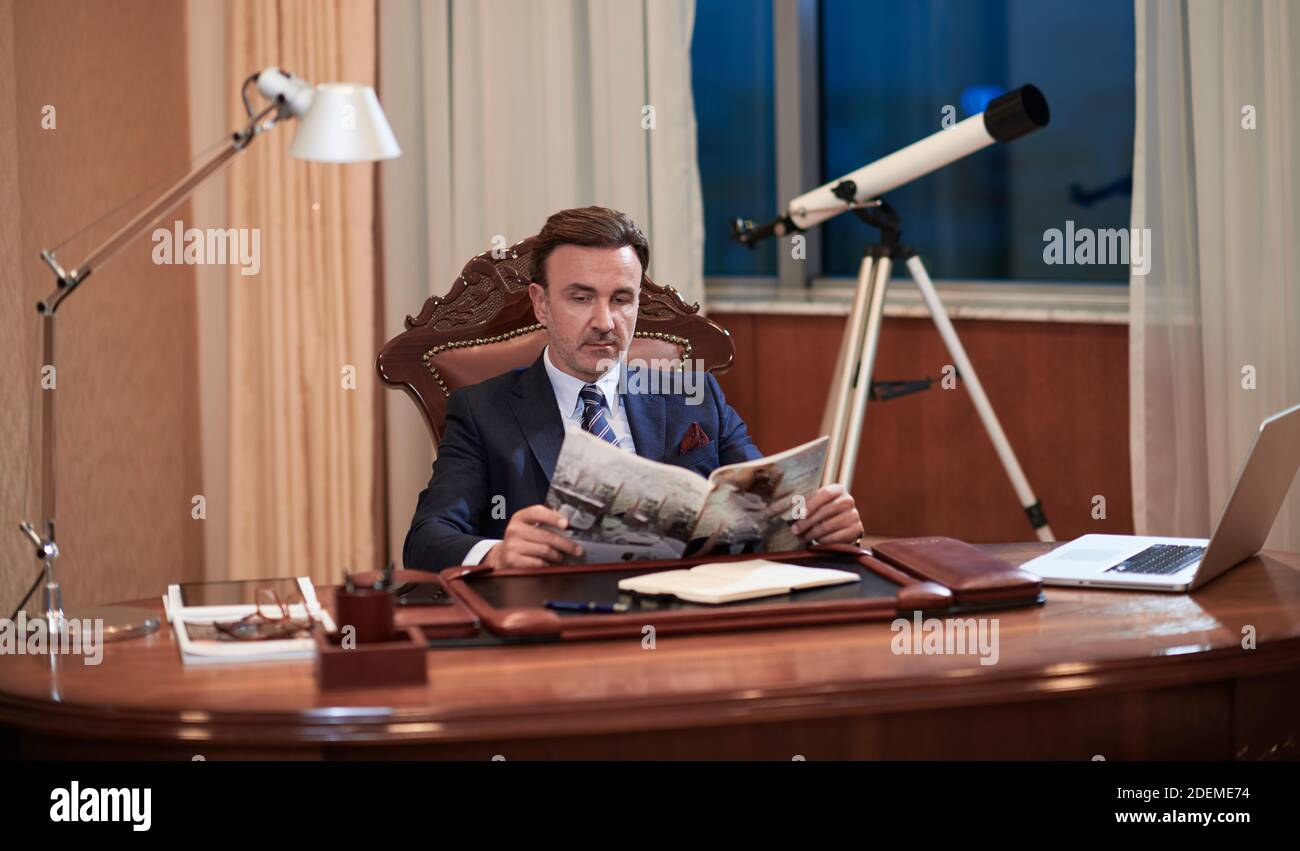 corporate business man at office reading magazine Stock Photo - Alamy