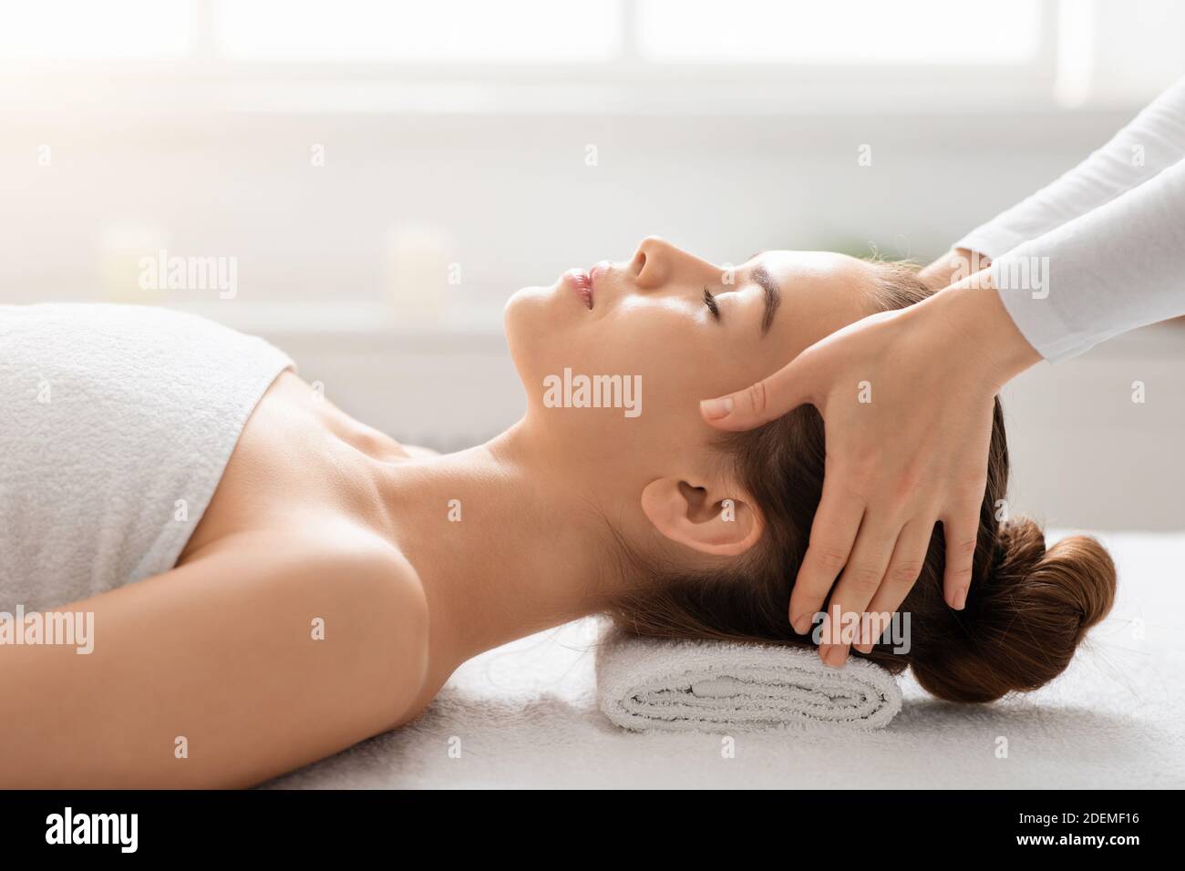 Masseuse Making Relaxing Head Massage For Young Beautiful Lady Stock