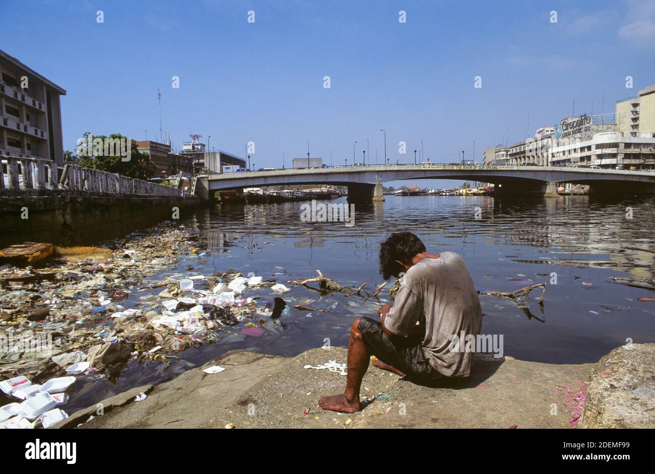 A poverty-stricken homeless man beside the Pasig River in Manila, Luzon ...