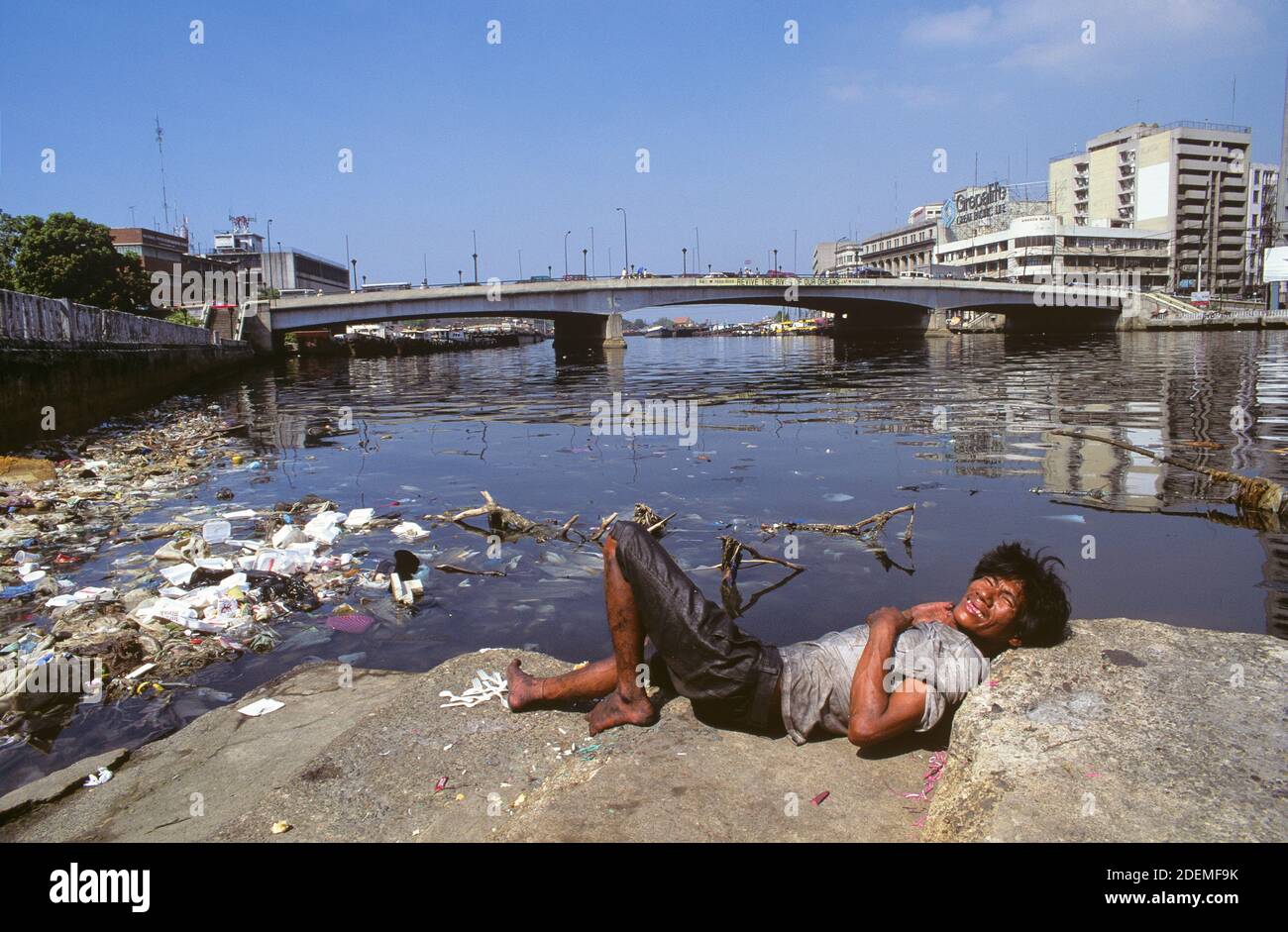 A poverty-stricken homeless man beside the Pasig River in Manila, Luzon ...