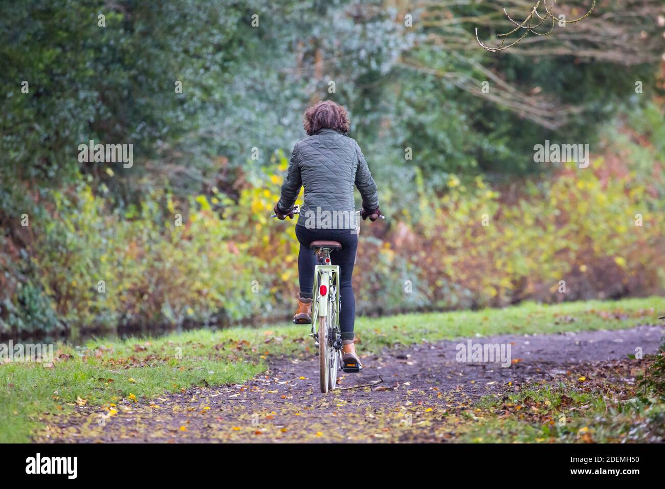 Rear view of isolated female cyclist riding her bike outdoors, cycling ...