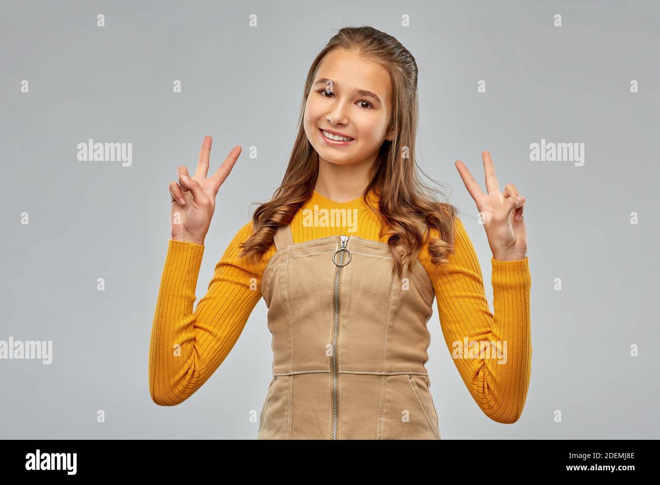 smiling young teenage girl showing peace hand sign Stock Photo - Alamy