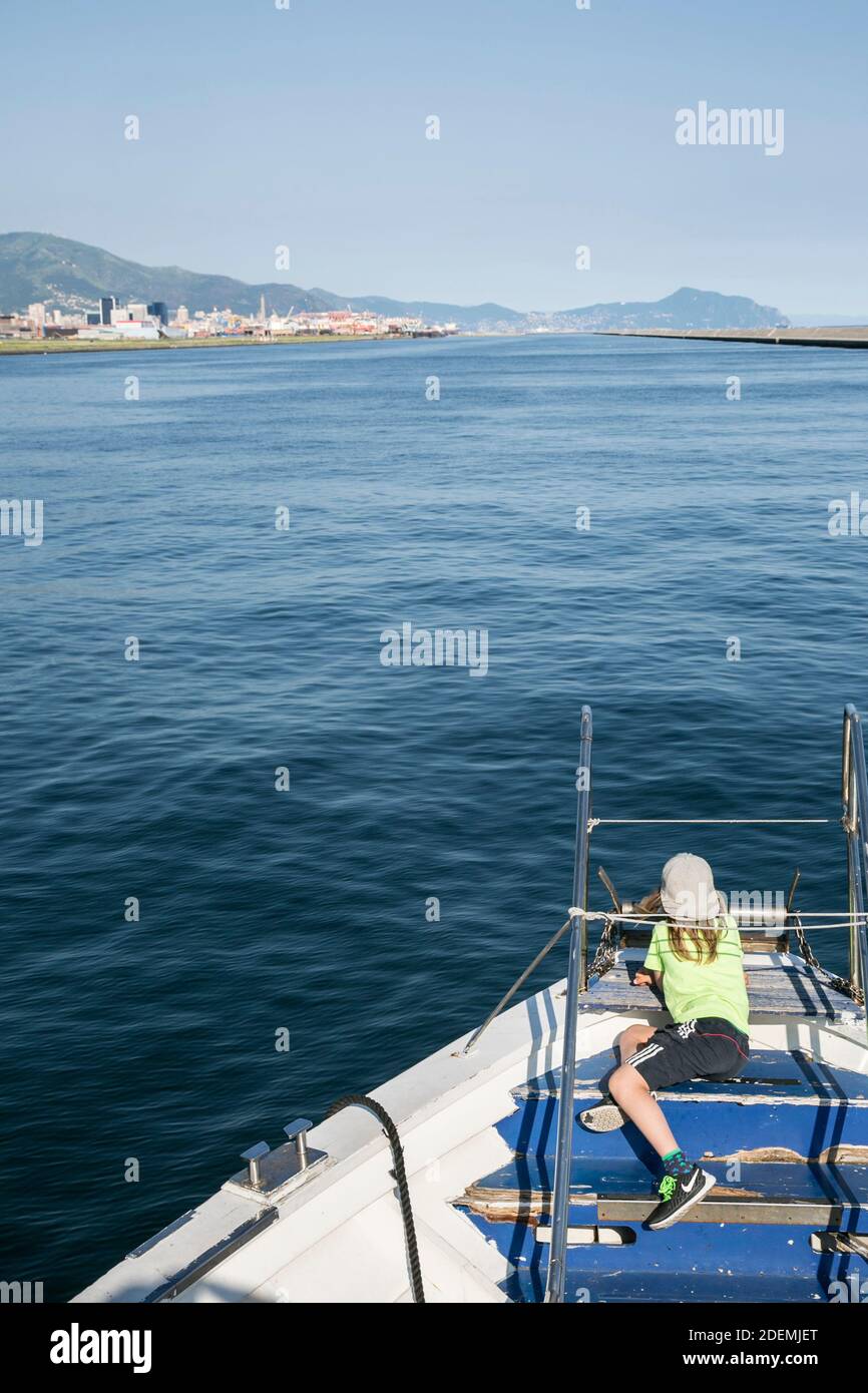 Boy on dock of a boat watching out toward the sea Stock Photo - Alamy