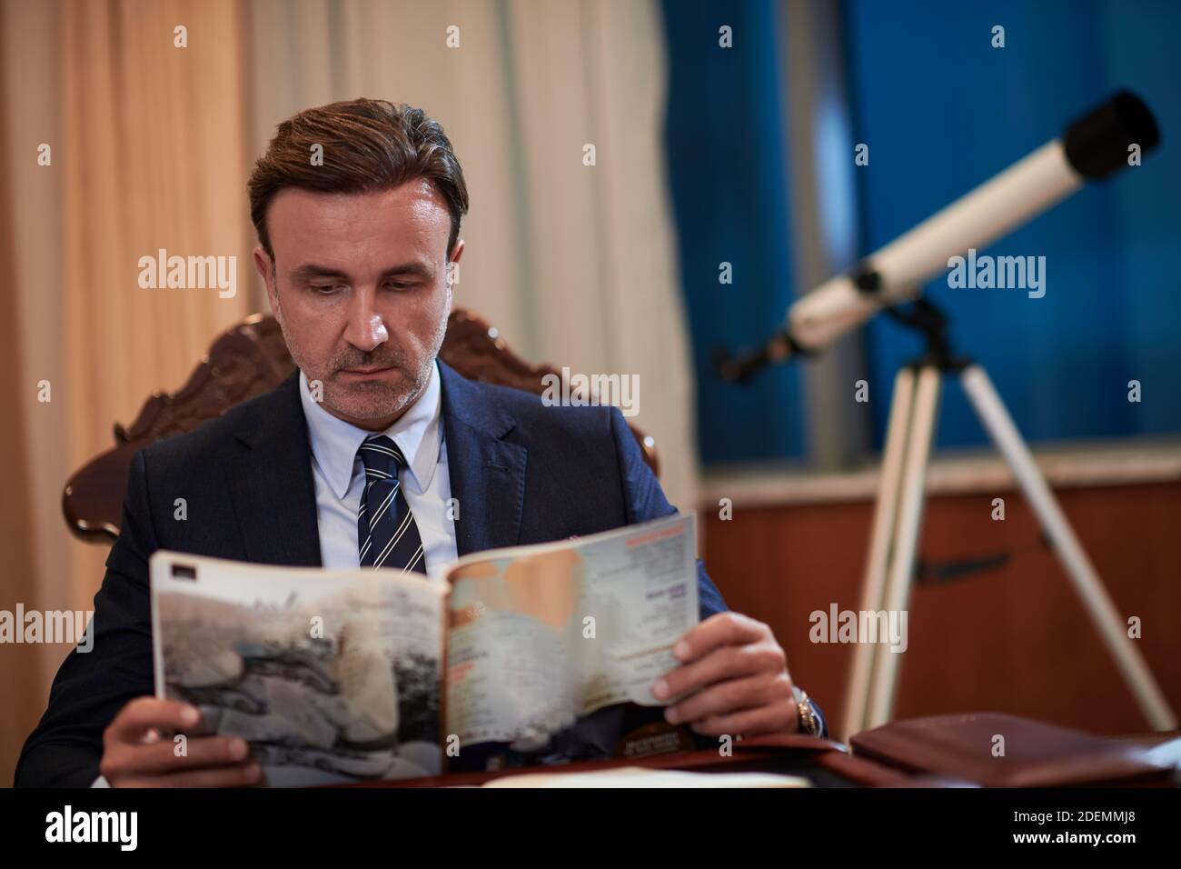 corporate business man at office reading magazine Stock Photo - Alamy