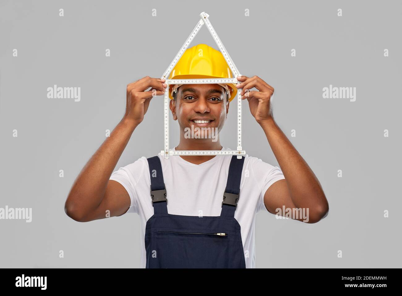 happy indian builder with ruler in shape of home Stock Photo - Alamy