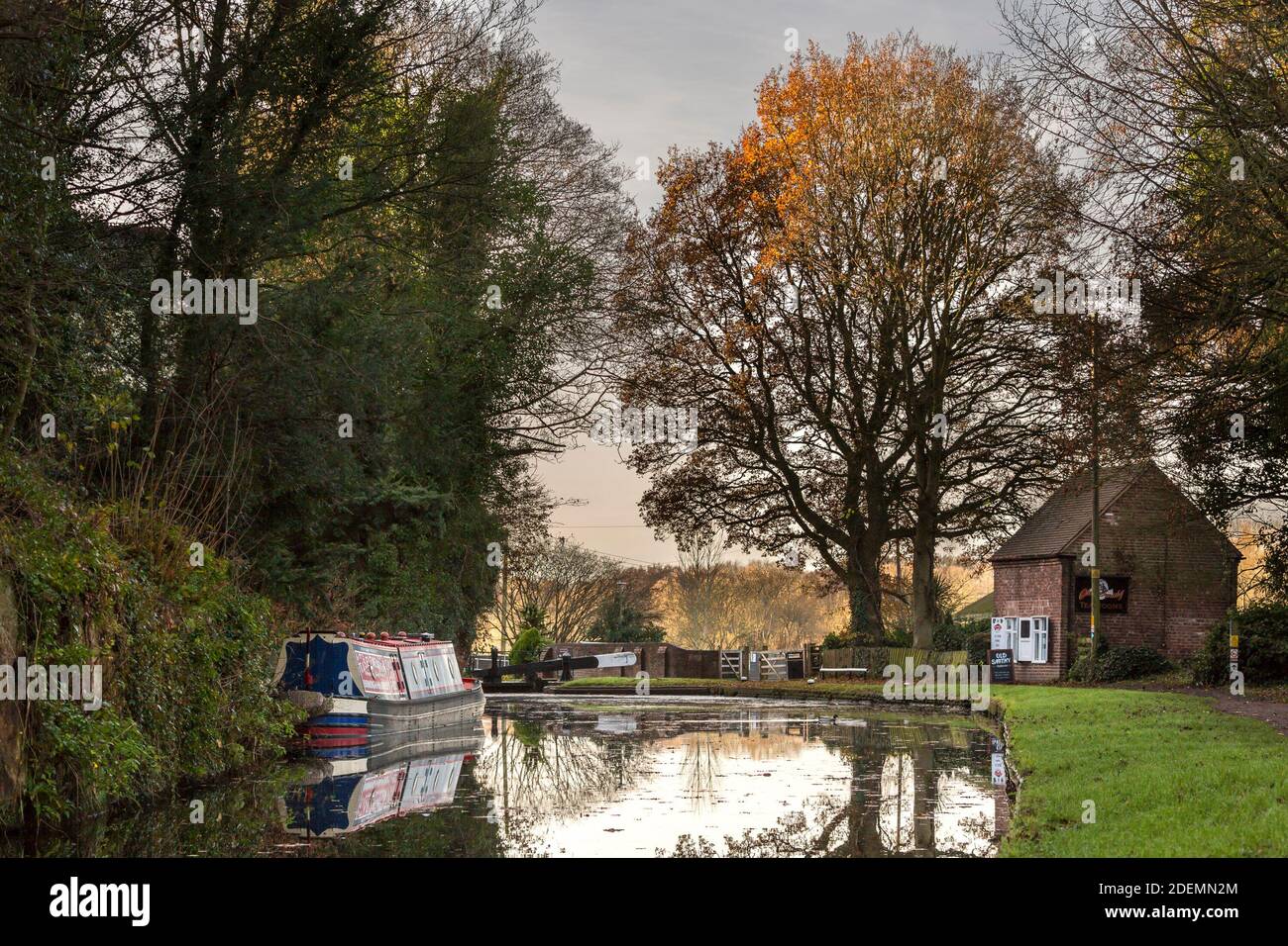 View of a UK canal during autumn at a lock with a small cafe building ...