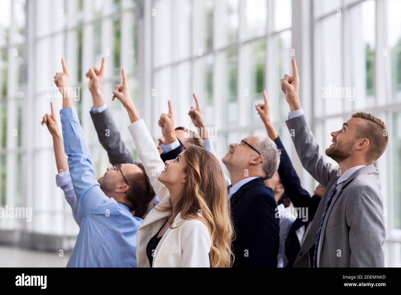 happy business team pointing finger up at office Stock Photo - Alamy