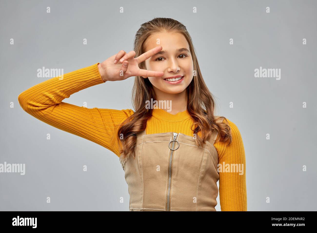 smiling young teenage girl showing peace hand sign Stock Photo - Alamy