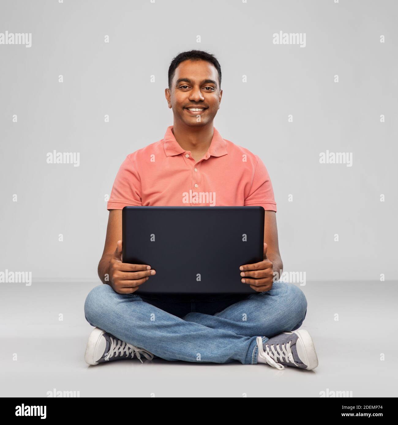 happy indian man with laptop computer on floor Stock Photo - Alamy