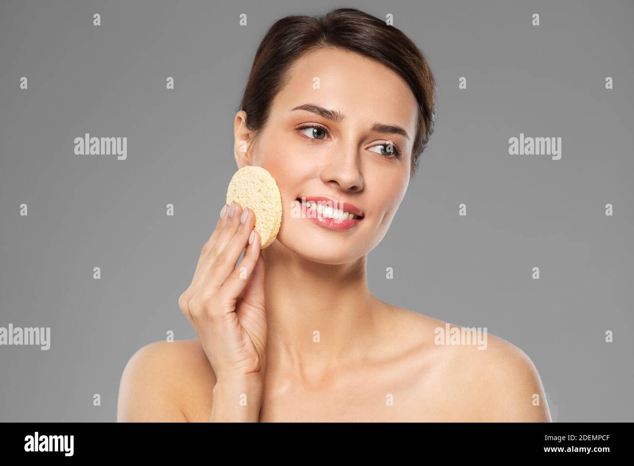 young woman cleaning face with exfoliating sponge Stock Photo - Alamy