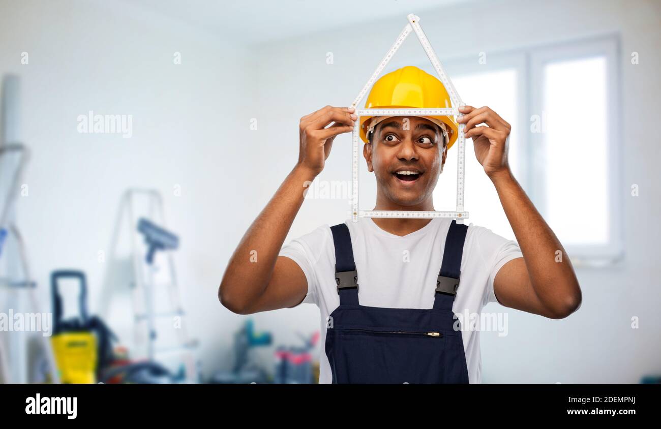 happy indian builder with ruler in shape of home Stock Photo - Alamy