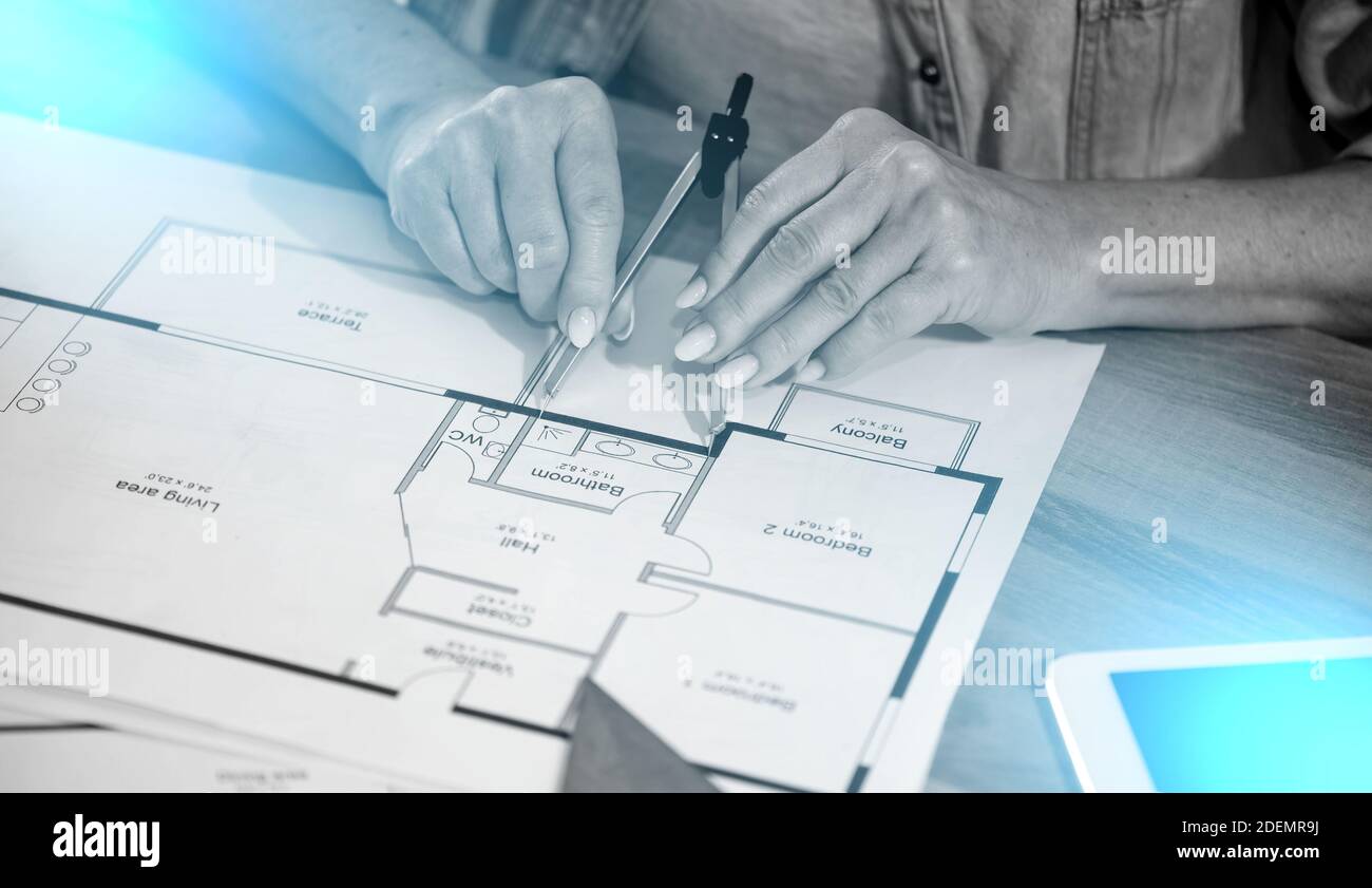 Female architect working on blueprint of new construction project ...