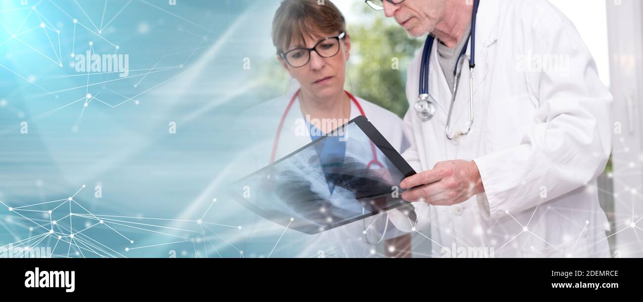Two doctors examining x-ray report in medical office; panoramic banner ...