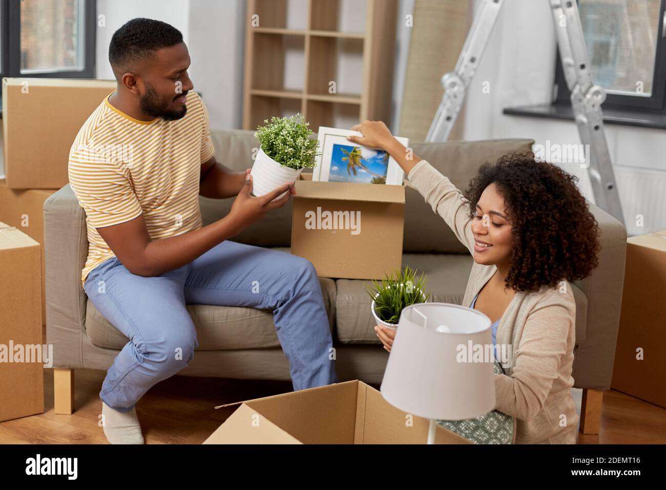happy couple packing boxes and moving to new home Stock Photo - Alamy