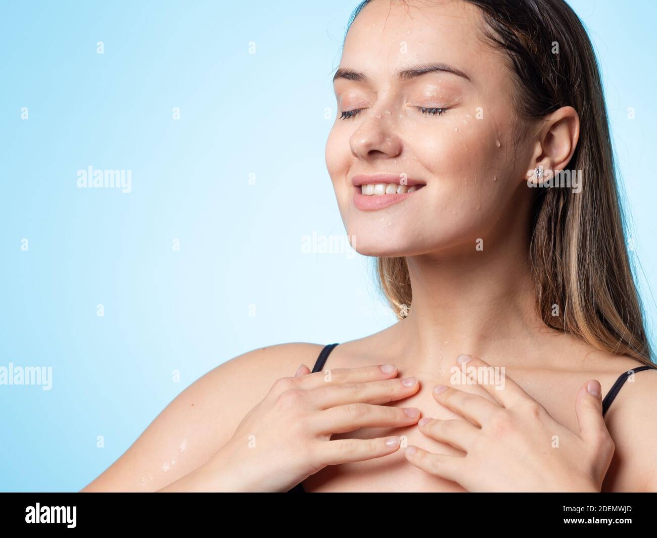 Clean skin, drops and trickles of water on the face. Young beautiful ...