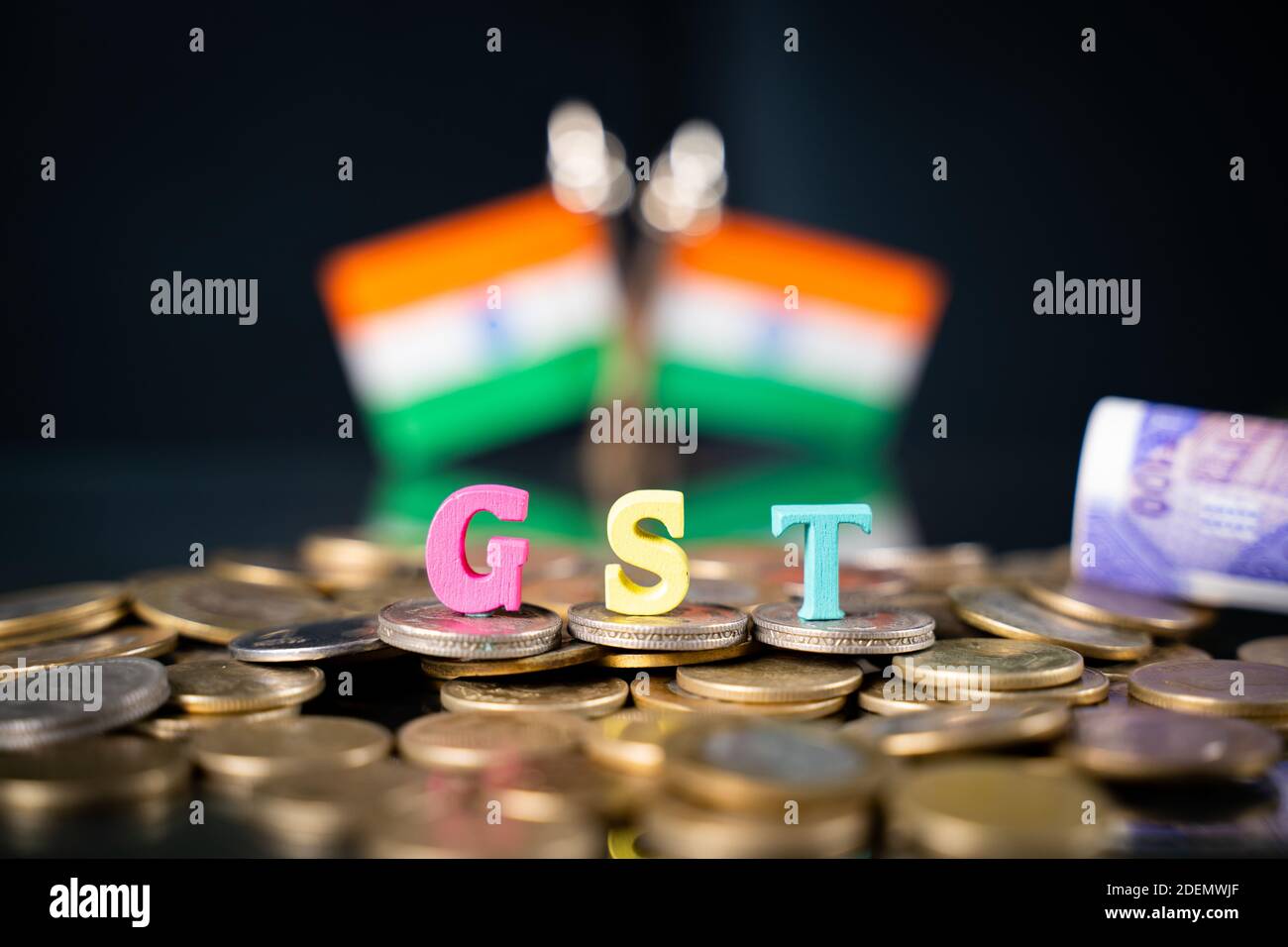 GST letters placed on coins with indian flag and currency note as ...