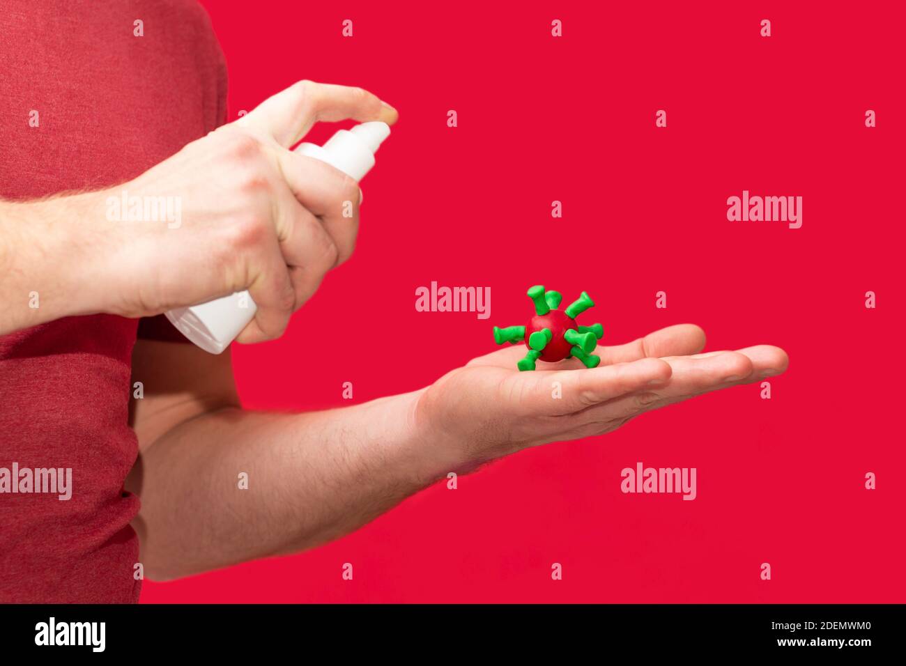 Male hand sprays antiseptic on a cell of the COVID-19 influenza virus ...
