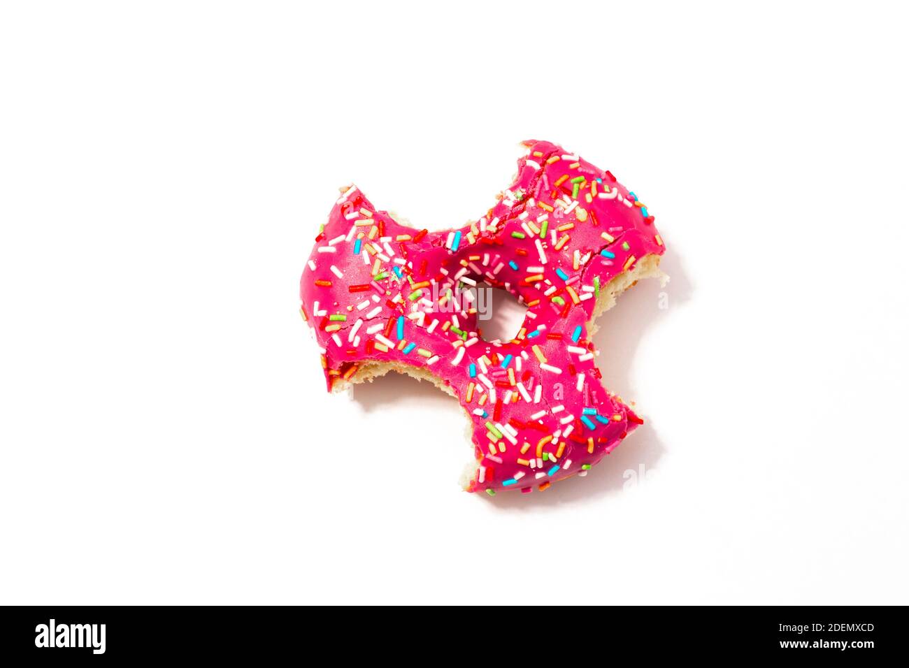 bitten pink donut in the shape of a spinner on a white background ...