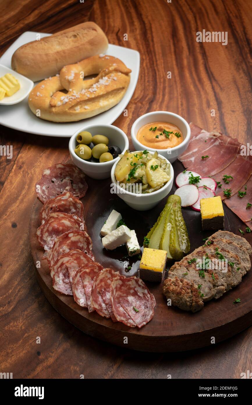 german cold cuts tapas snack platter with meats and bread on wood table ...