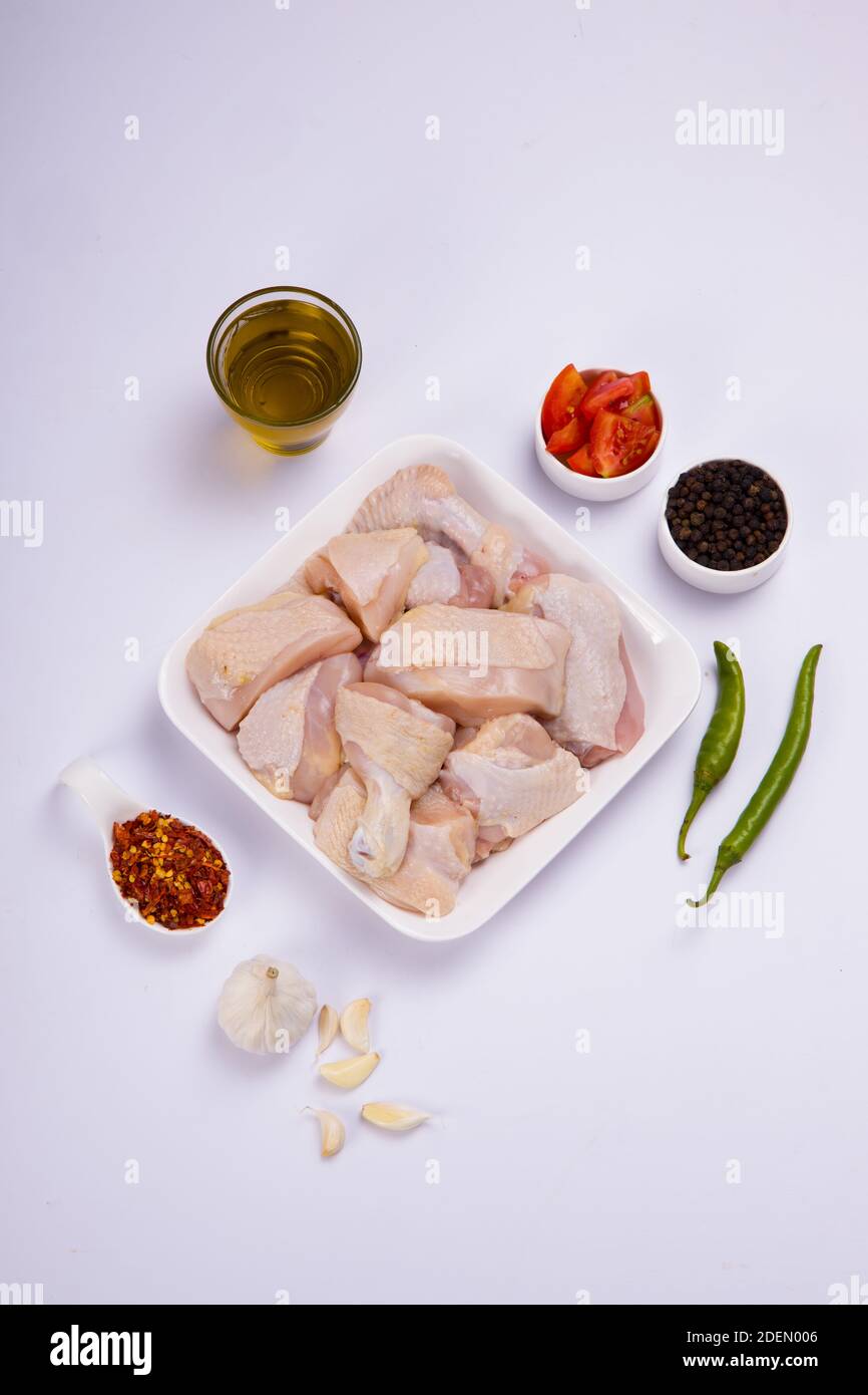 Raw chicken tender curry cut with skin arranged on white plate and ...