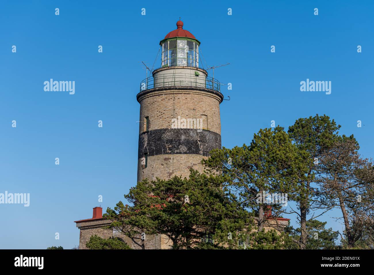 A brick lighthouse with a bright blue sky in the background. Picture of ...