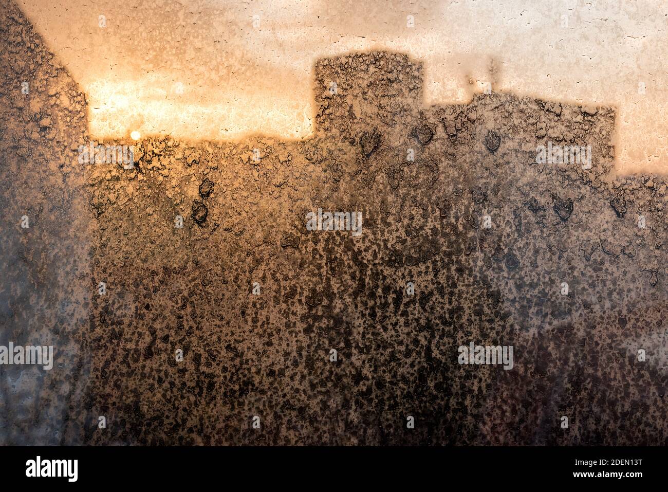 Dirty window glass with dust and dried raindrops backlit with a sunset ...