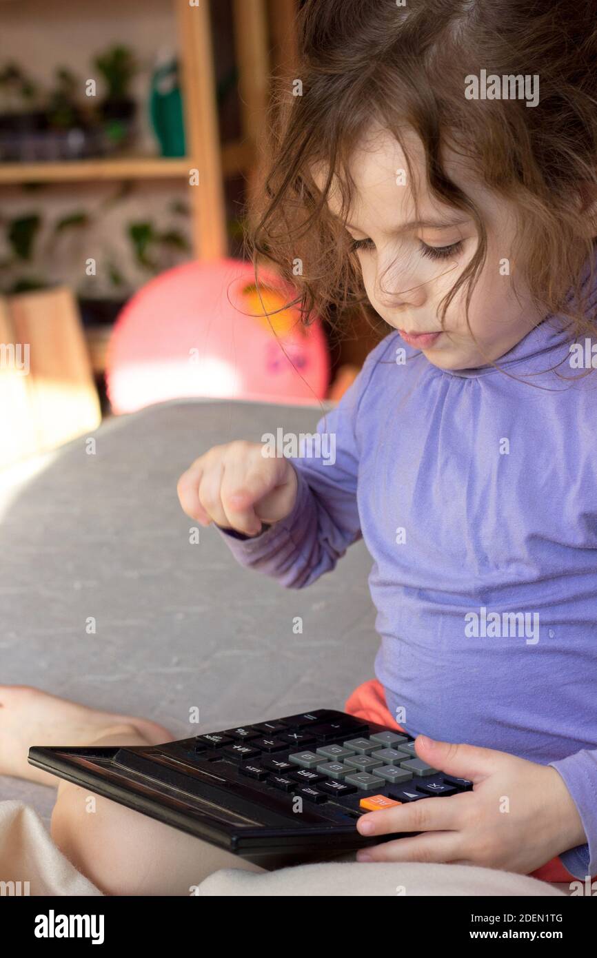 Little kid girl with a calculator in hands Stock Photo - Alamy