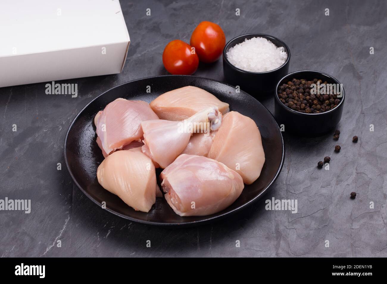 Raw chicken tender curry cut without skin arranged on black plate and ...
