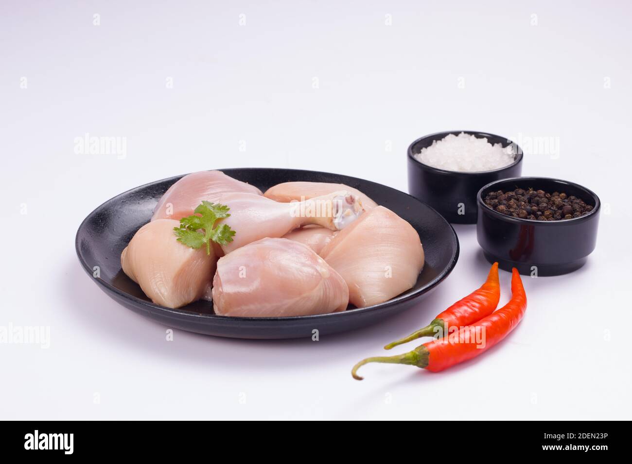 Raw chicken tender curry cut without skin arranged on black plate and ...