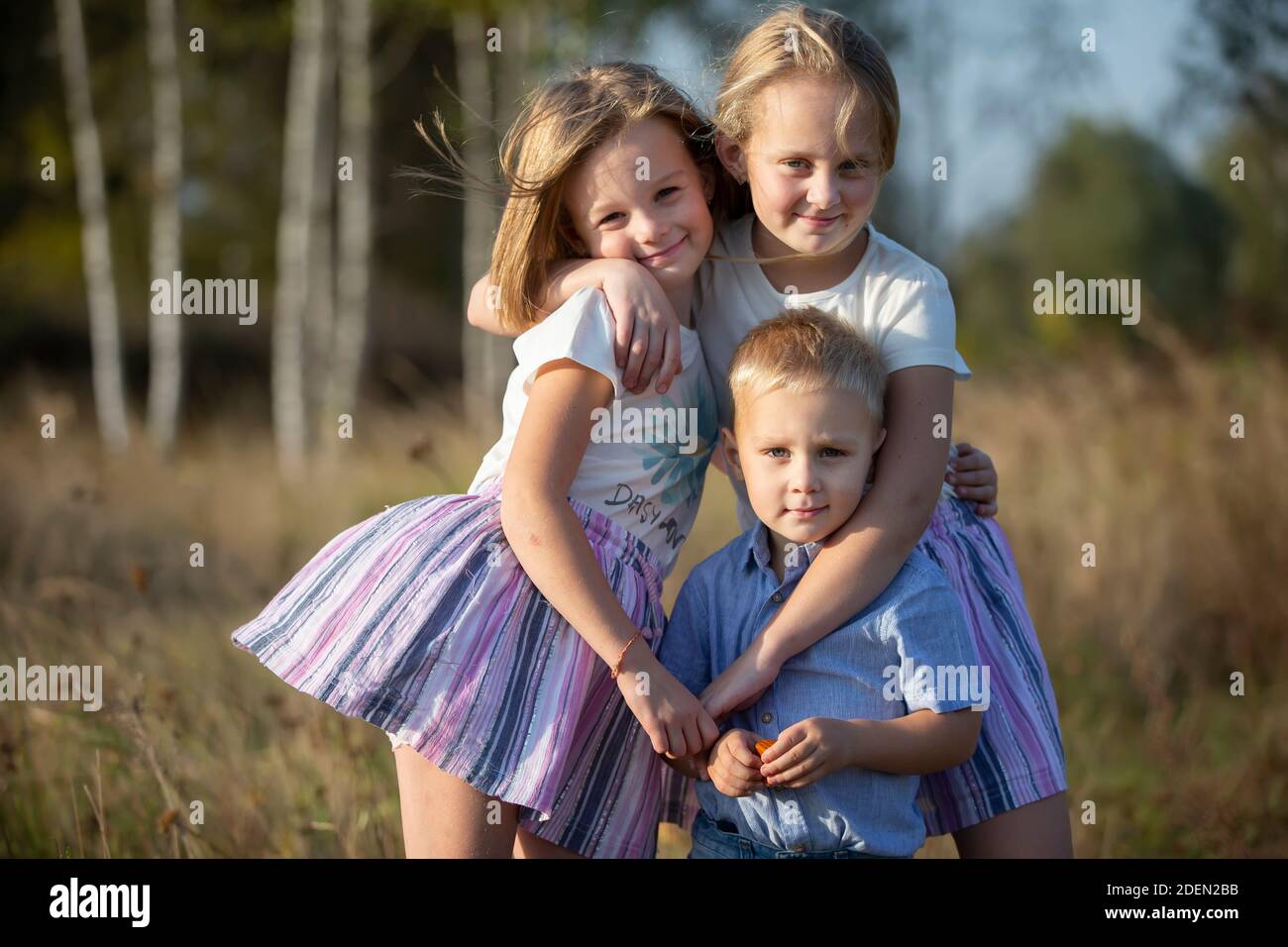 Little brother and two sisters are looking at the camera Stock Photo ...
