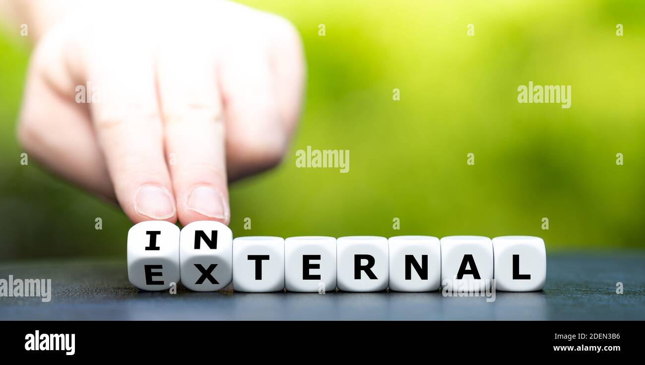 Hand turns dice and changes the word external to internal Stock Photo ...