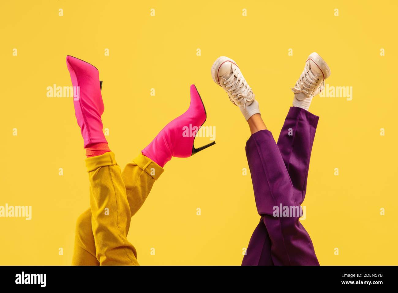 Fashion model's feet in bright stylish footwear isolated on yellow ...