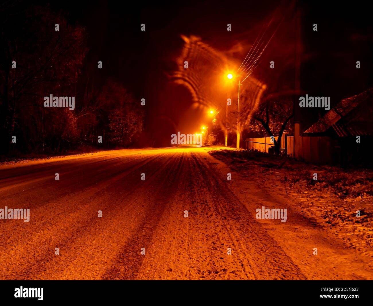 Night winter snowy road for cars in the light of lanterns. Snow on a ...